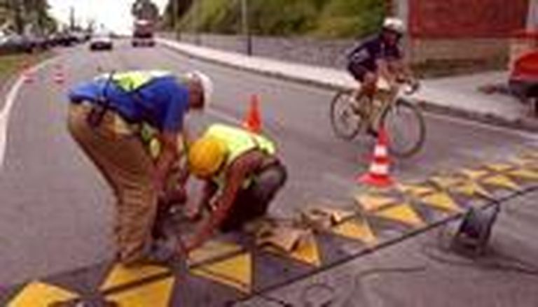 Bandas rugosas frente a pasos de peatones realzados en la calzada